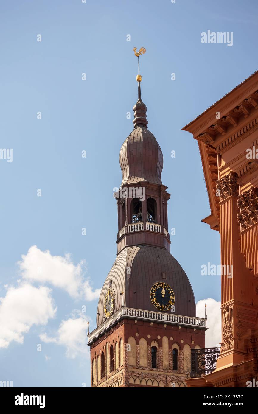 A church with a brown wall and a pointed metal tip in the middle of the ...