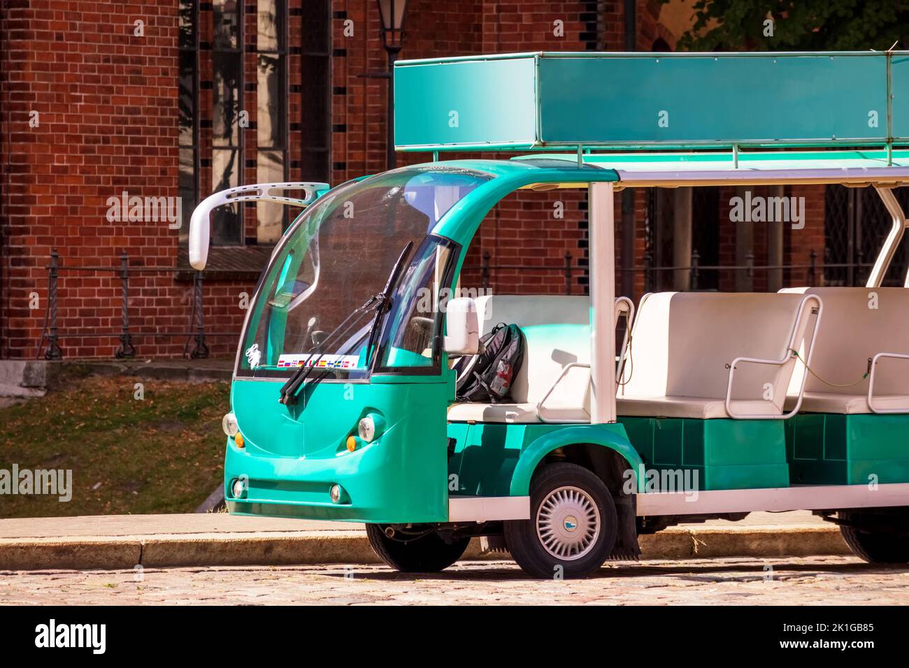 A green tourist bus with white seats located in the middle of the city ...