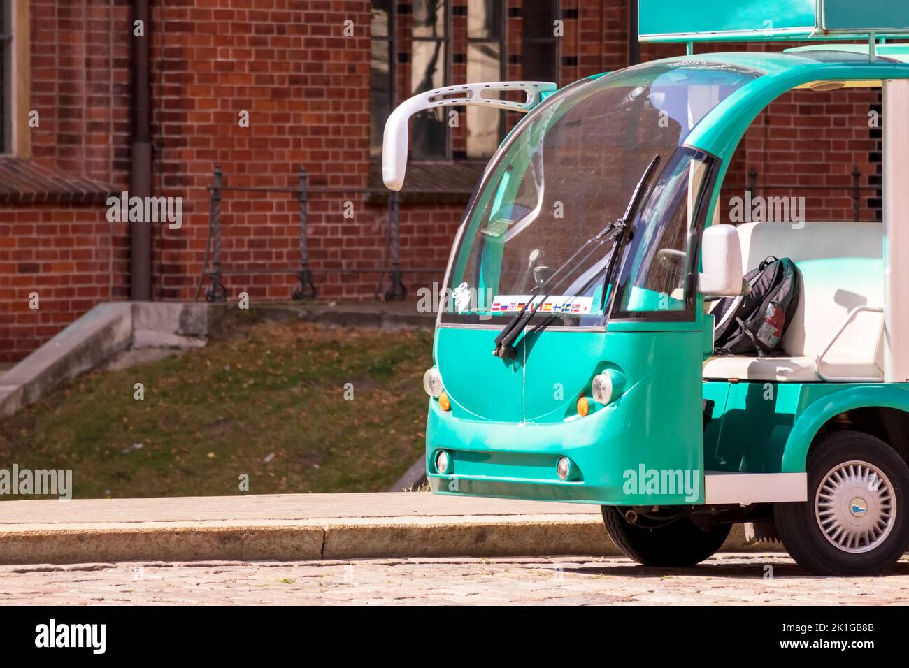 A green tourist bus with white seats located in the middle of the city ...