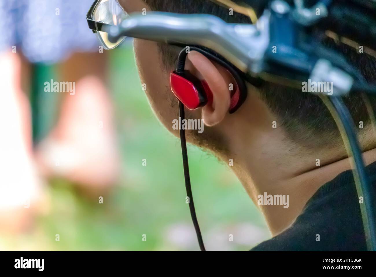 Back view of a human head with a red music headphone in his ear Stock ...