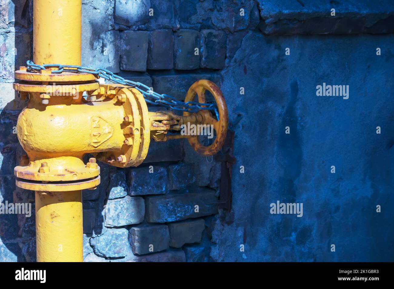 Yellow water metal pipe with tap on gray brick background Stock Photo ...