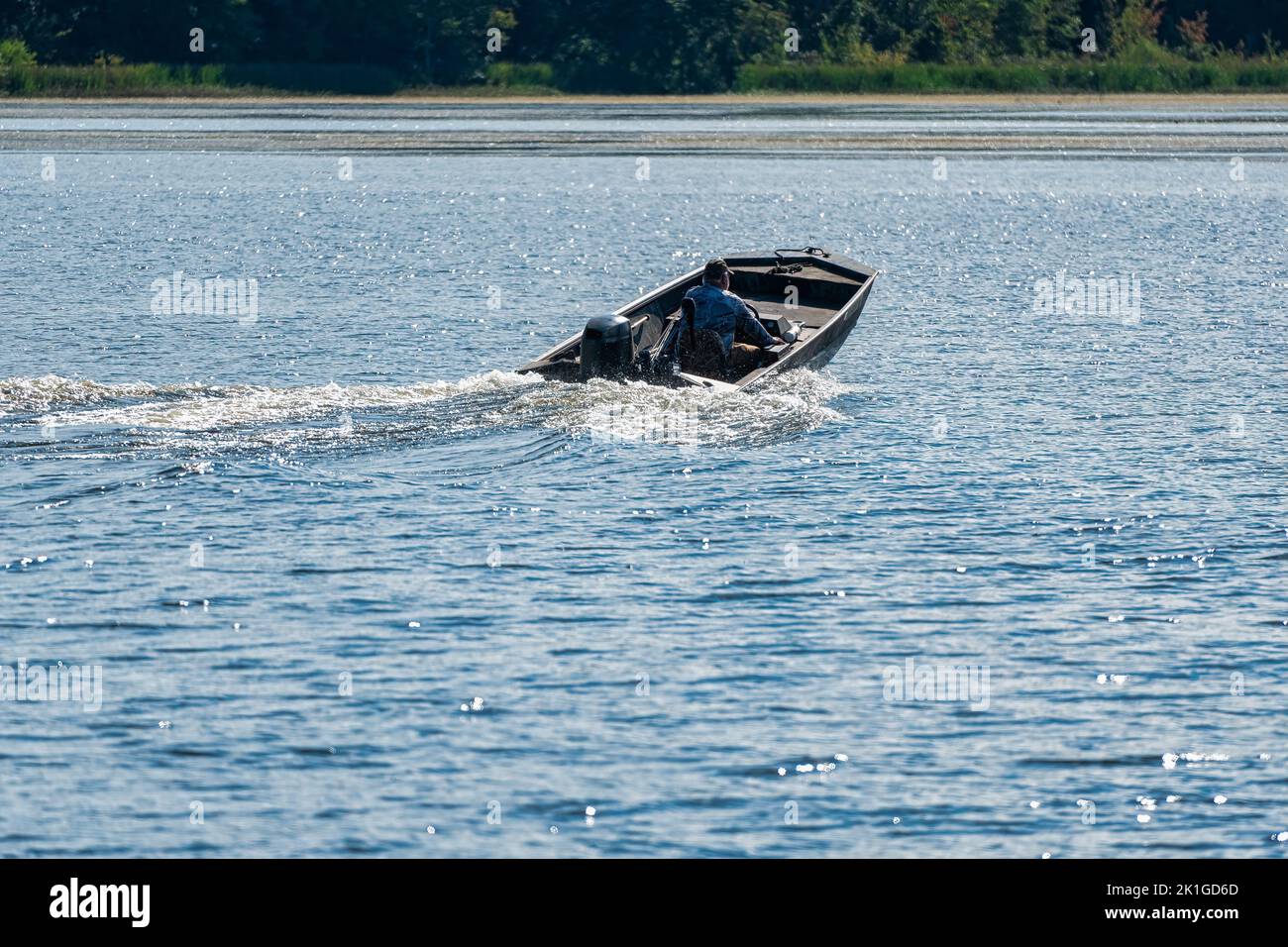 Man in a fishing boat heading up the river to catch fish, on ...