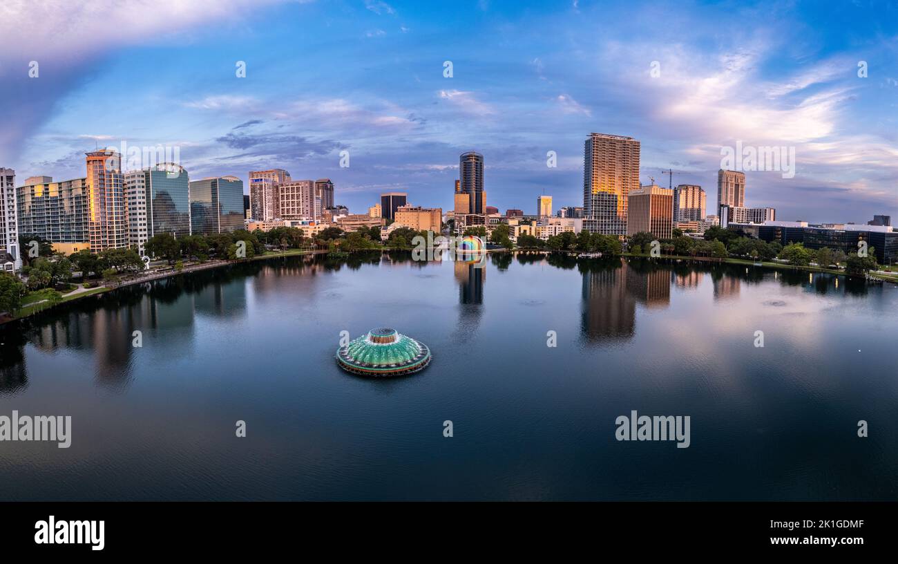 An aerial view of lake Eola and the Orlando city skyline at sunrise ...