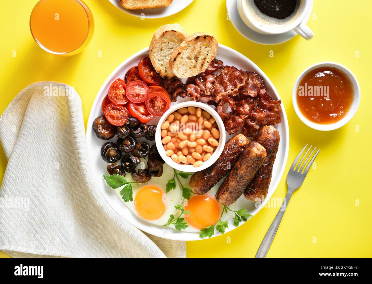 Full english breakfast with fried egg, bacon, sausage, beans and ...