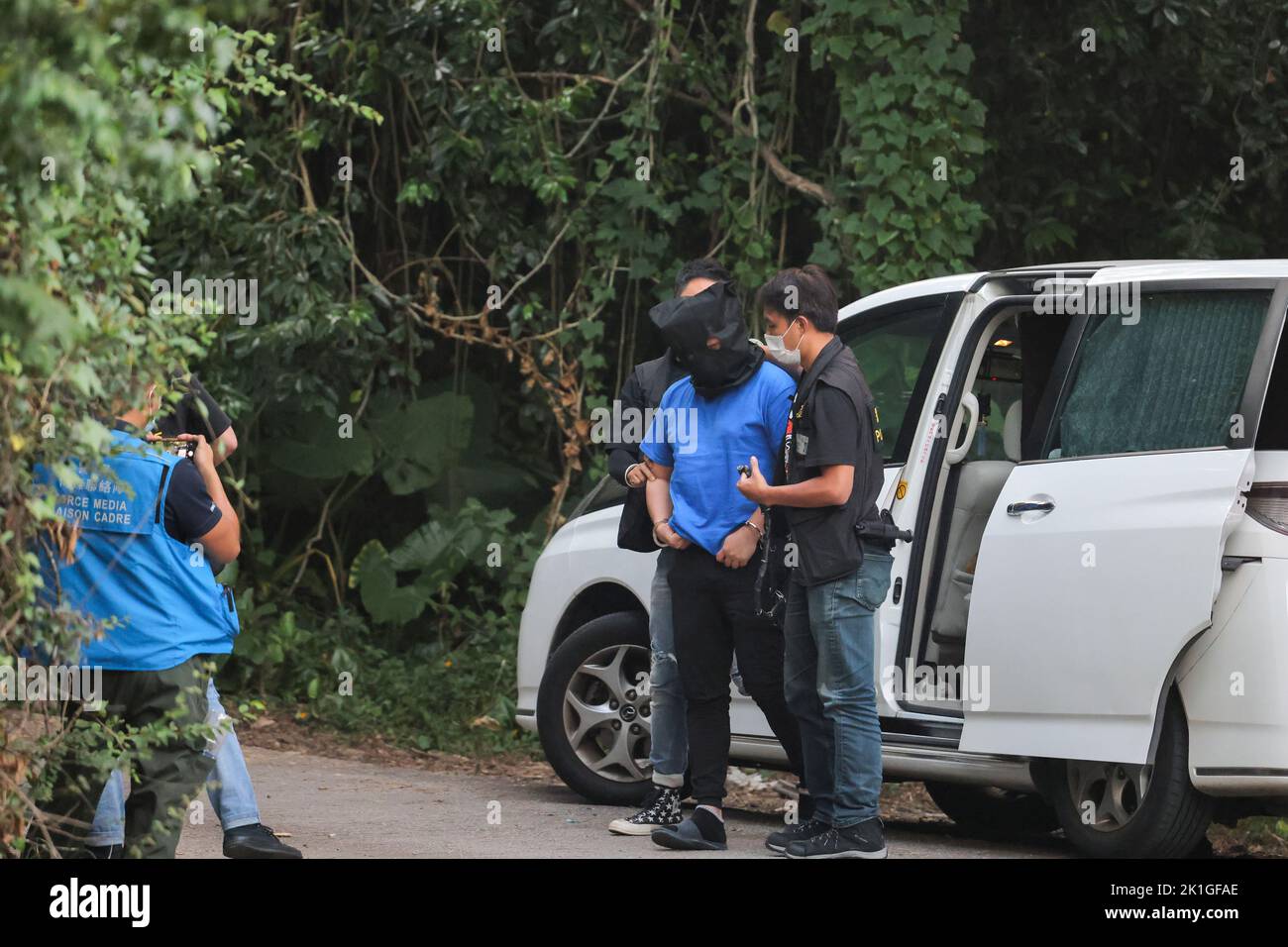 A suspect escort by police officers at a hillside near Ping Yeung ...