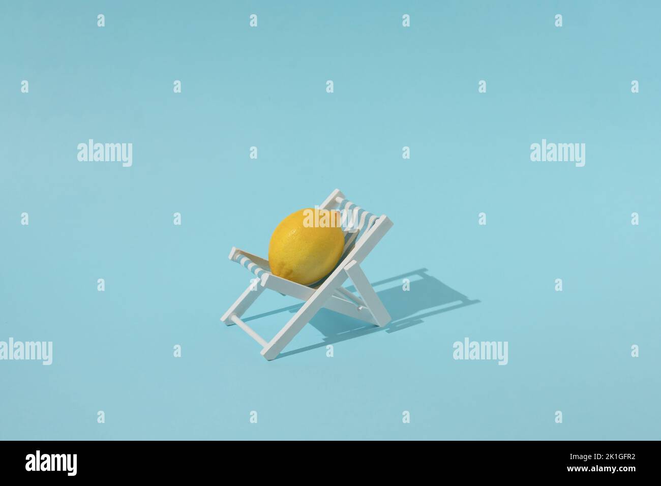 Fresh lemon on a beach chair with blue background. Colorful creative ...