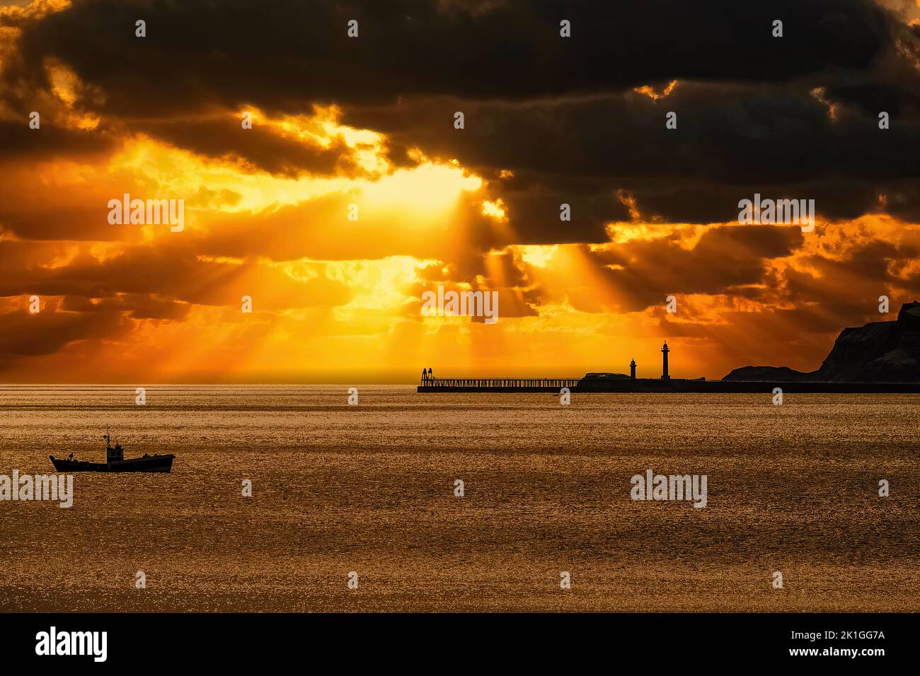 Whitby harbour at sunrise, shot from the beach at Sandsend which is ...