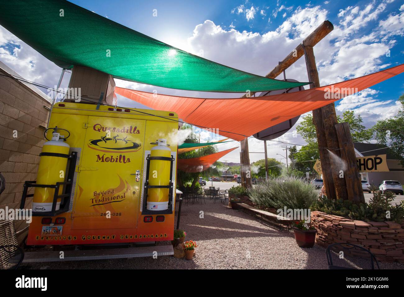 A colourful Mexican street food stall with red and green sun shades in ...