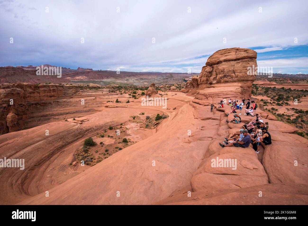 People sitting down on the rocks enjoying the view near Delicate Arch in Utah USA Stock Photo ...