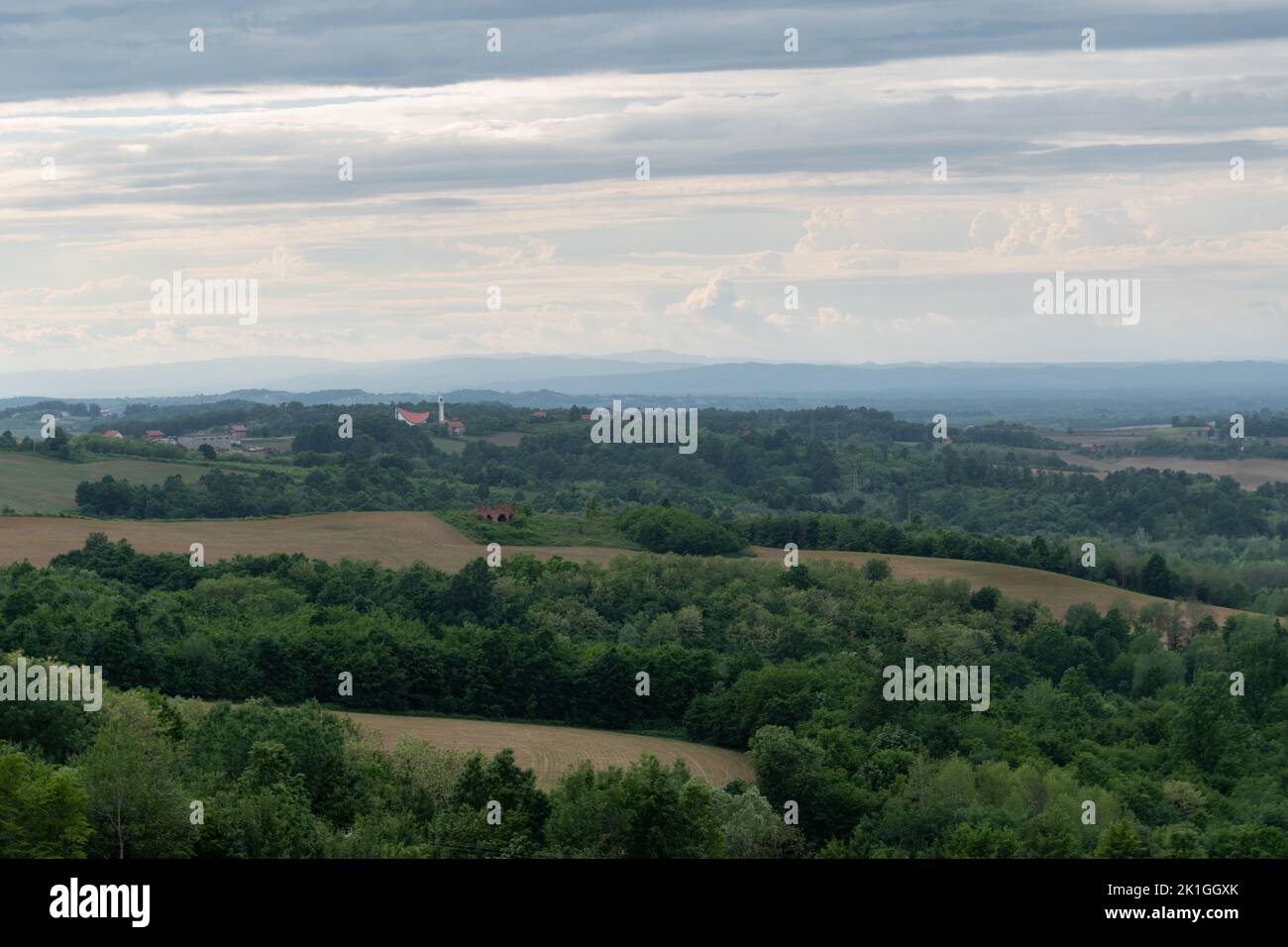 Rural landscape with forests and arable fields in spring during cloudy ...