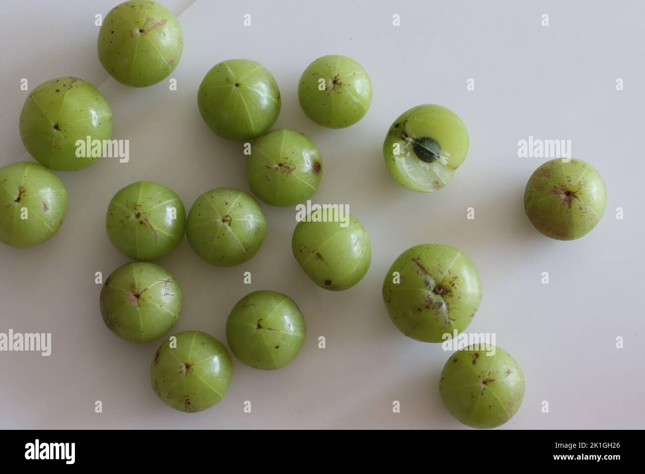 Amla or gooseberries shot on a white background. A translucent green ...