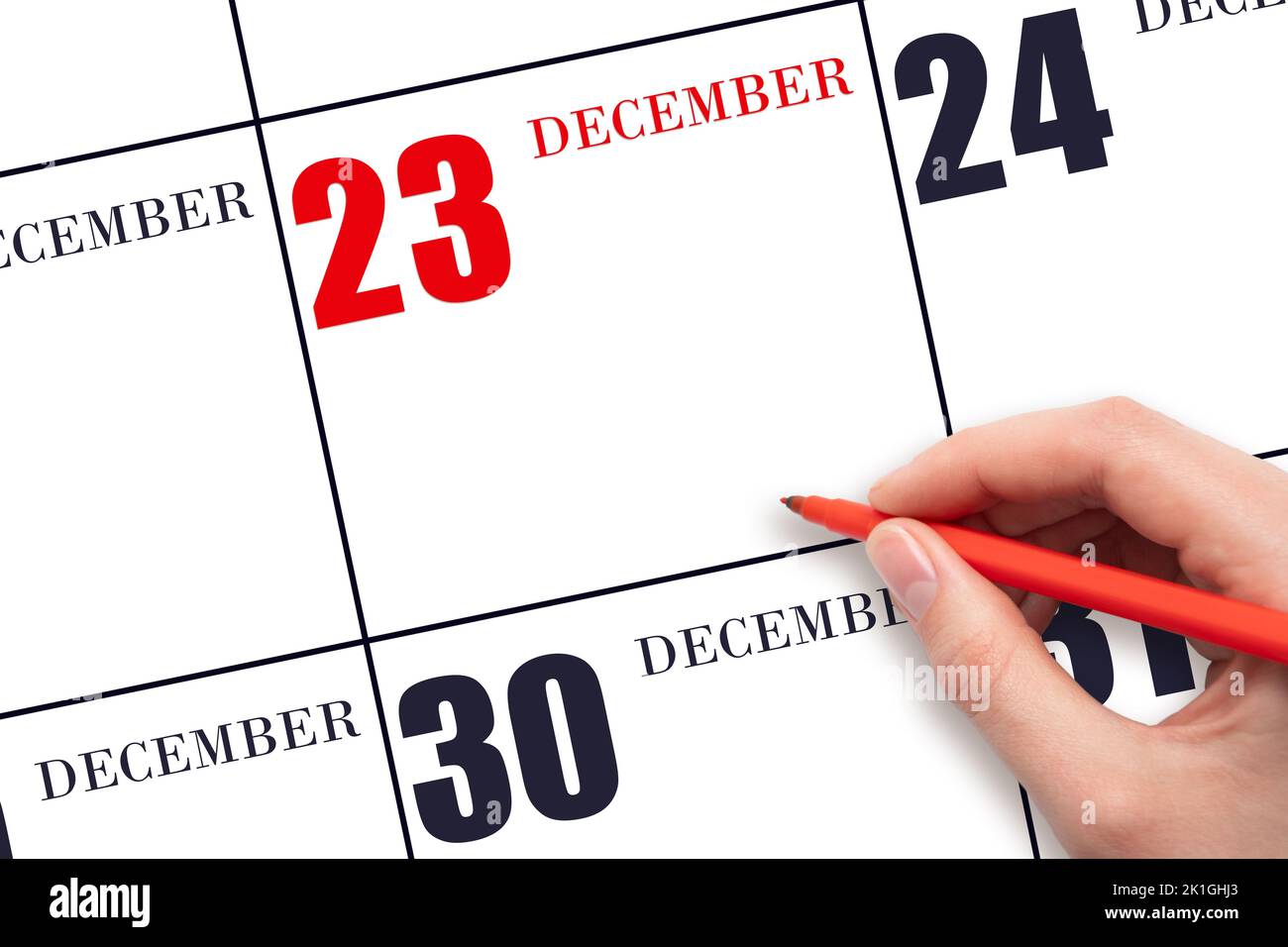 23rd day of December. A hand holding a red pen and pointing on the ...