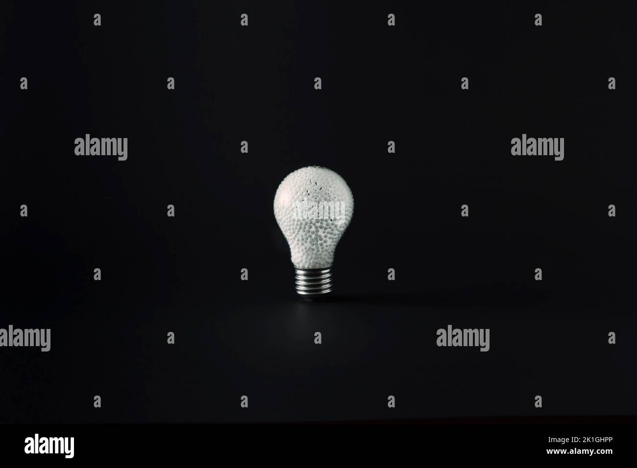 Light bulb filled with white styrofoam beads on black background Stock ...