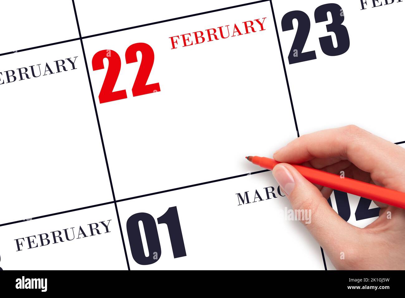 22nd day of February. A hand holding a red pen and pointing on the ...