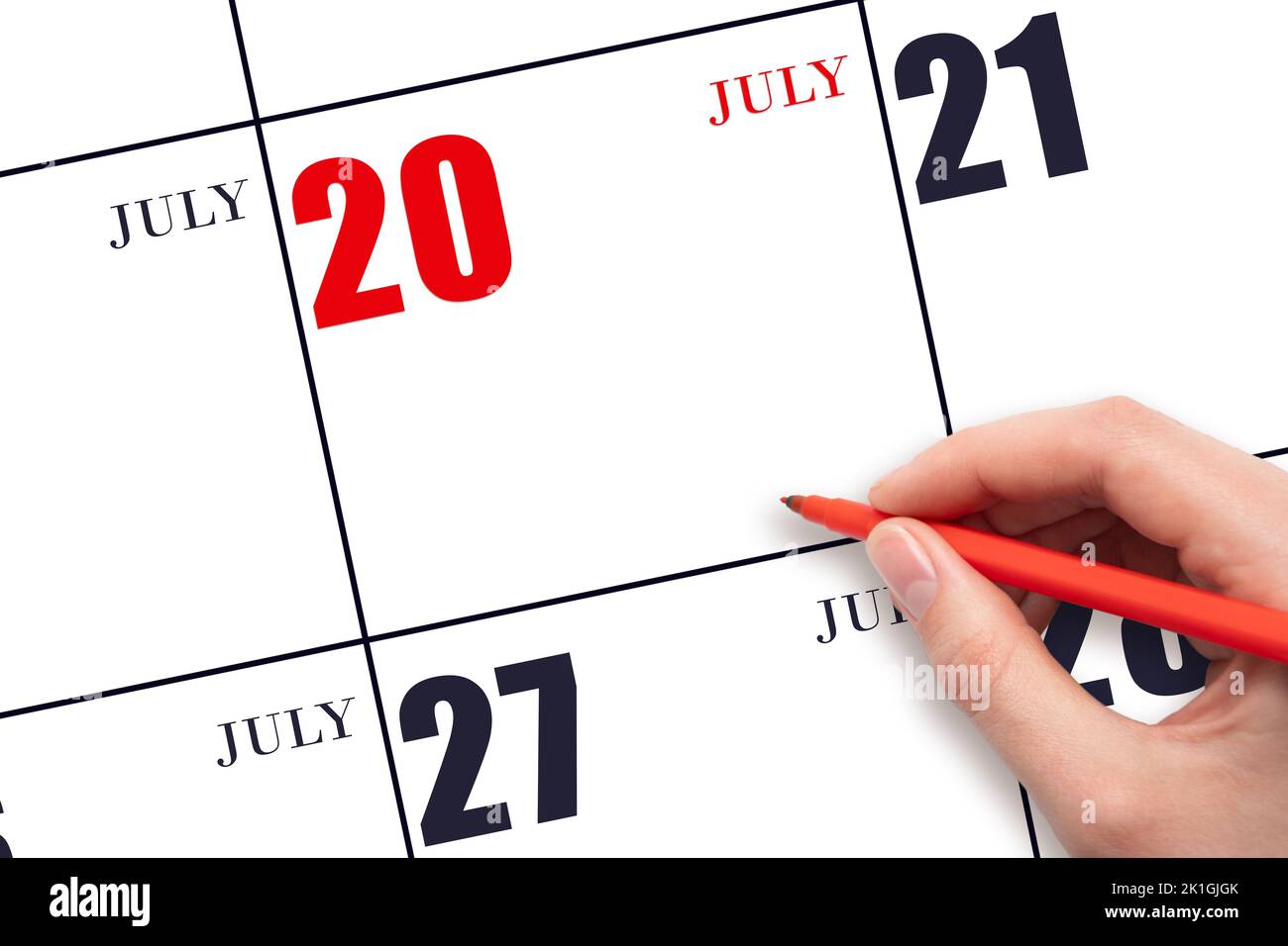 20th day of July. A hand holding a red pen and pointing on the calendar ...