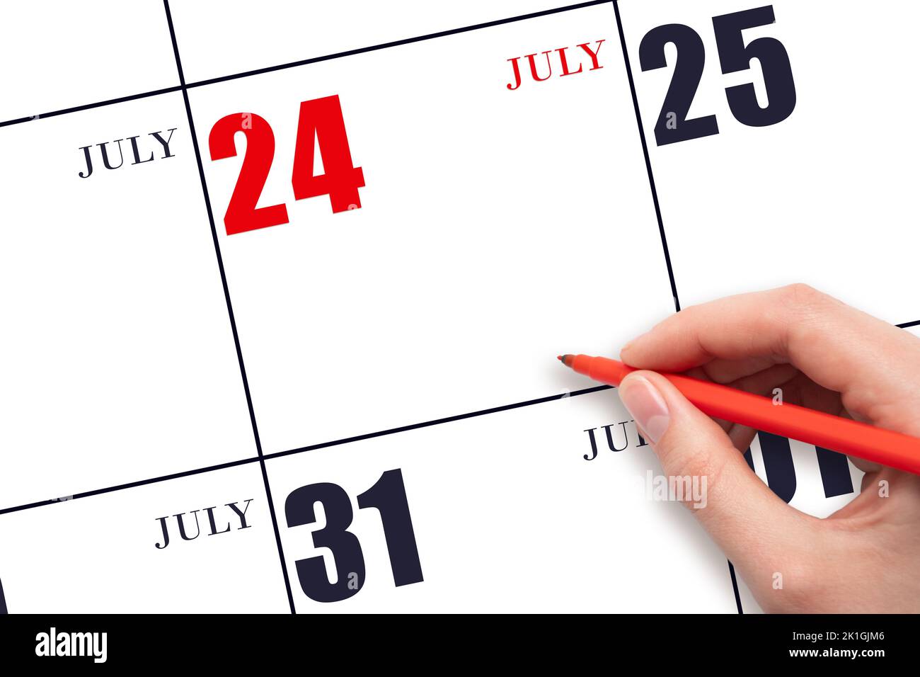 24th day of July. A hand holding a red pen and pointing on the calendar ...
