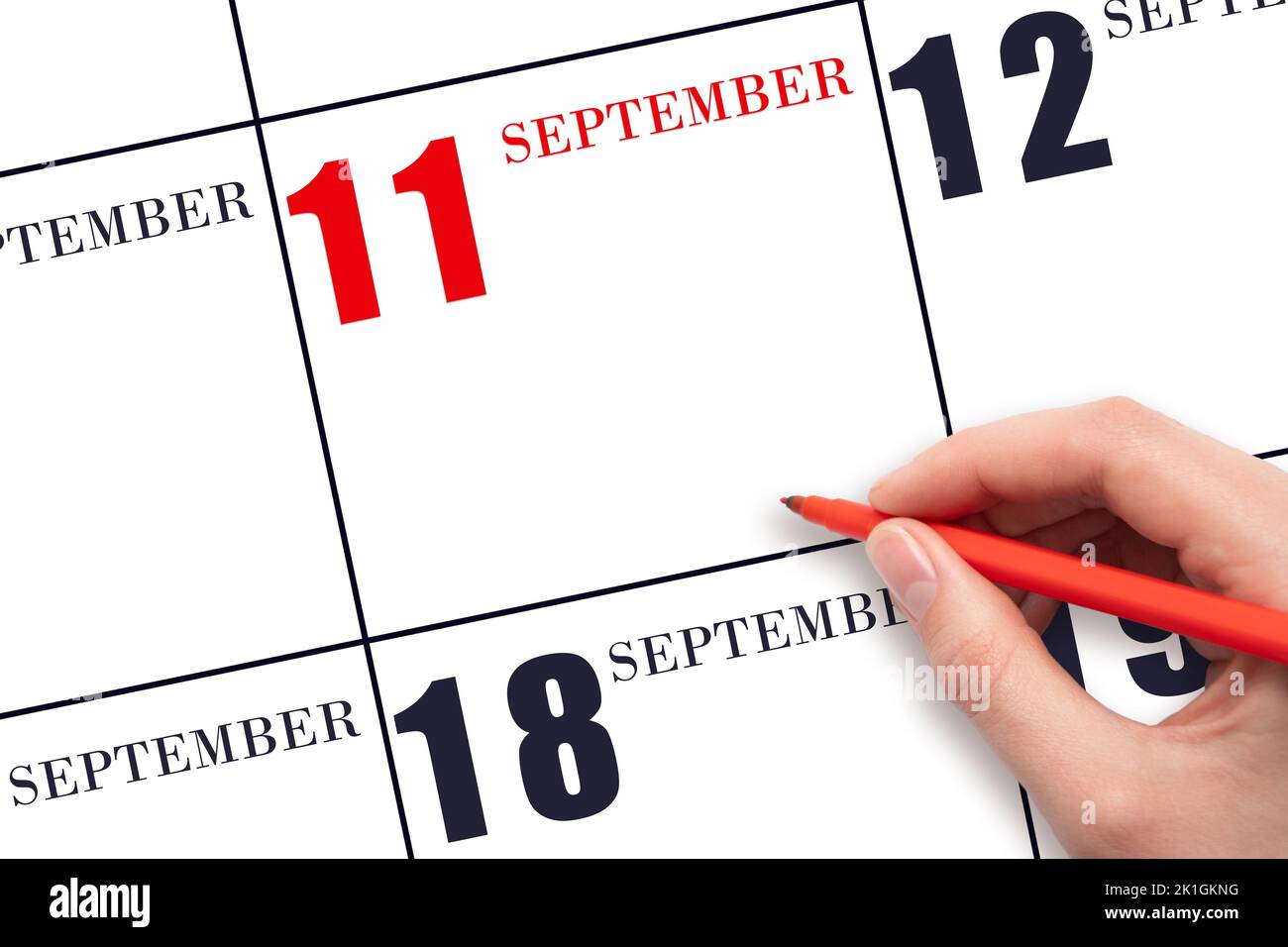 11th day of September. A hand holding a red pen and pointing on the ...