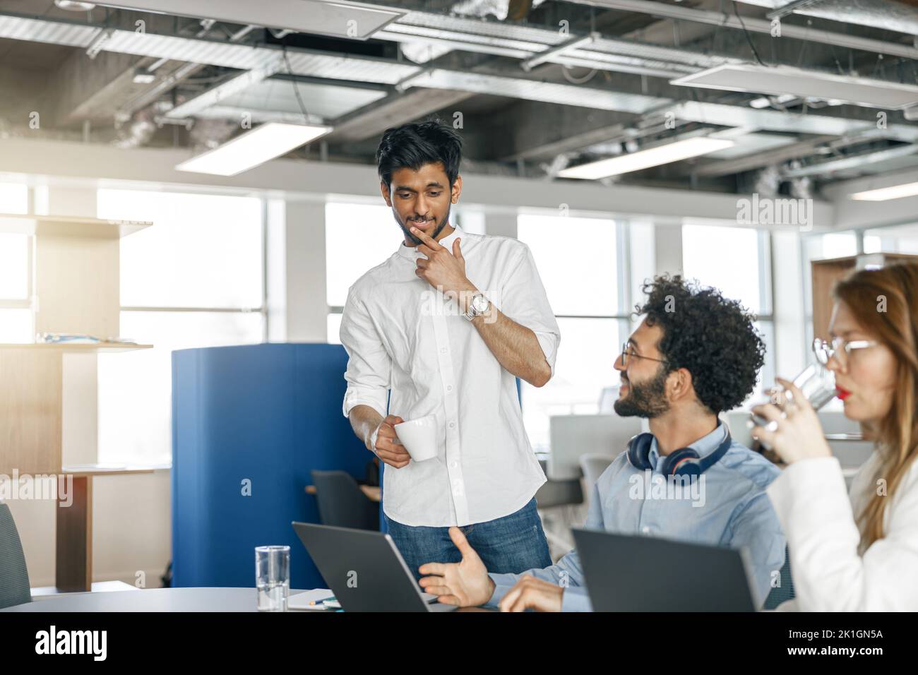 Group of busy coworkers working together analyzing the charts in modern ...
