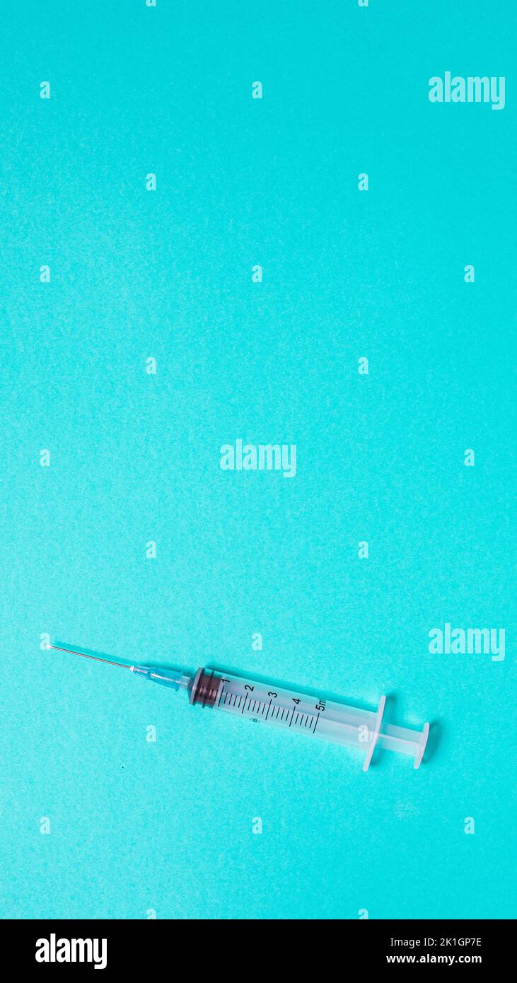 Syringe on pastel blue background from above Stock Photo - Alamy