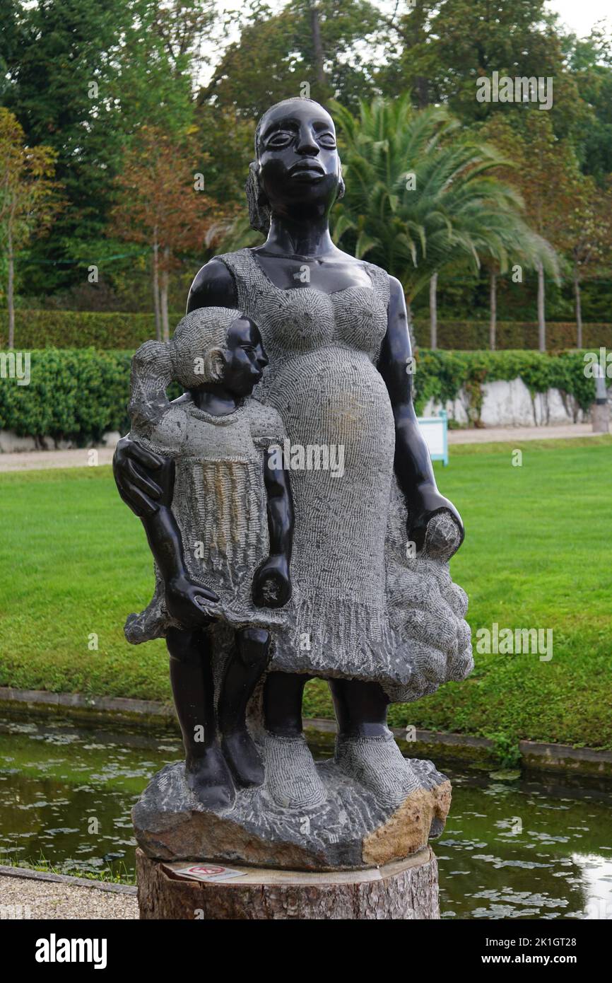 A vertical shot of a beautiful stone sculpture of mother and daughter ...