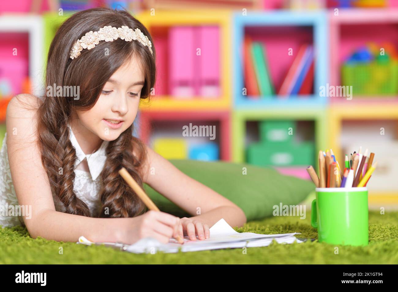 Beautiful little girl draws with a pencil on a sheet of paper Stock ...