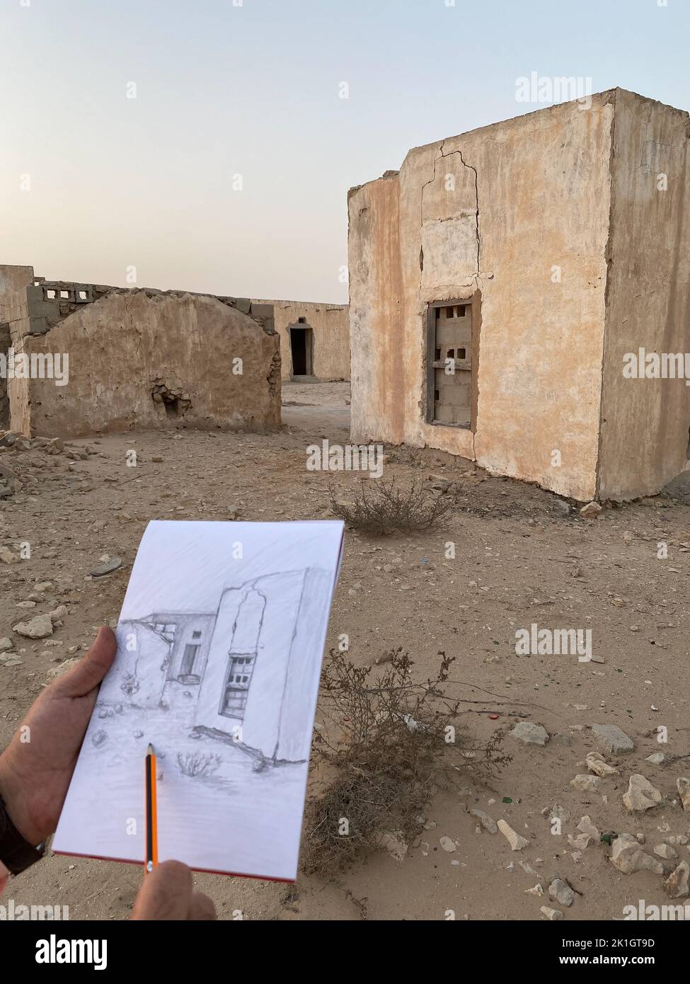 A vertical shot of a human drawing the old buildings of a village in ...