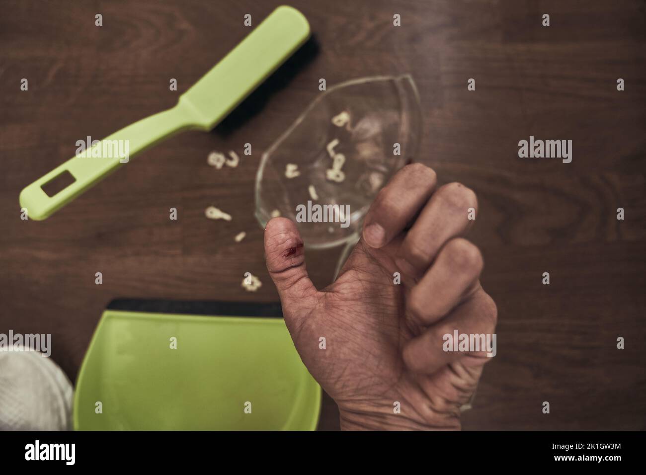 Close-up of a cut female finger on the background of a split cup and a ...