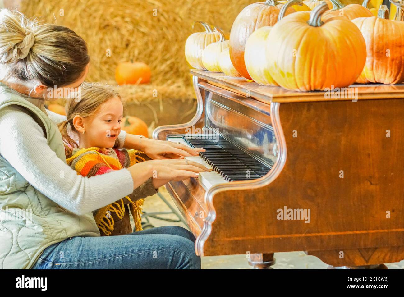 Mother teaching her daughter how to play piano in halloween season ...