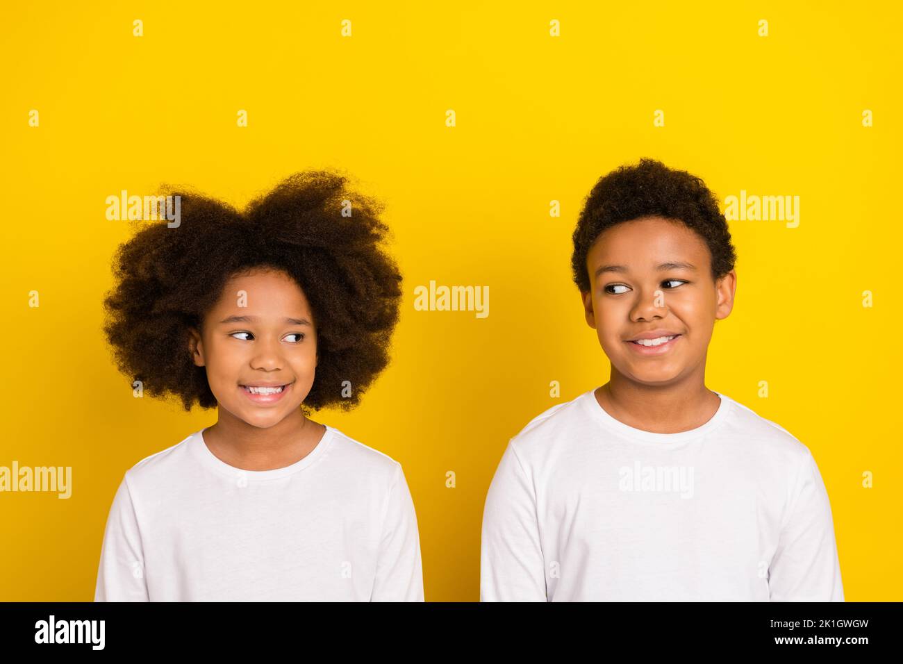 Portrait of positive minded siblings look interested each other ...