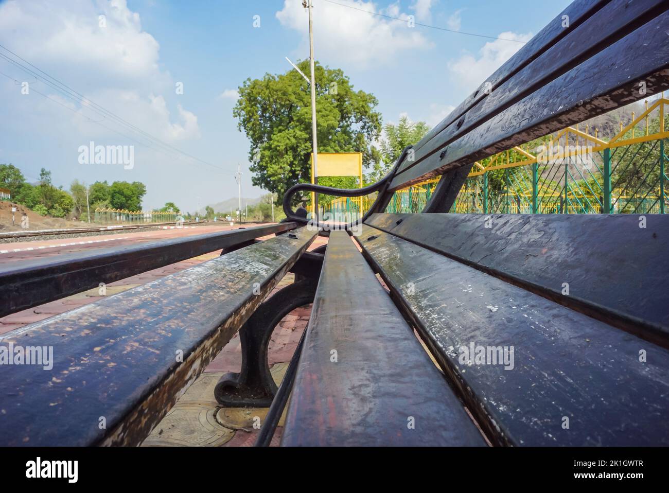 Blank railway sign board, seating bench at railway station platform of ...
