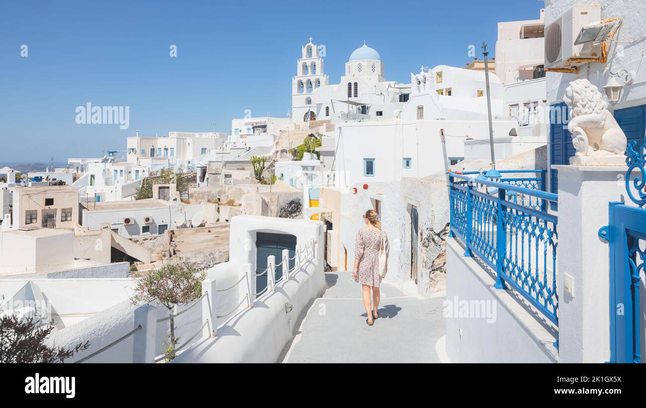 A young blonde female tourist explores the traditional old town streets ...