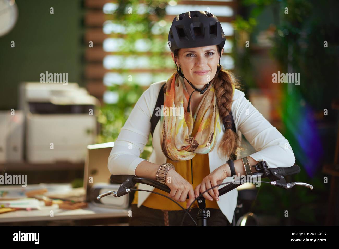 Portrait of elegant business woman in bike helmet with bicycle in ...