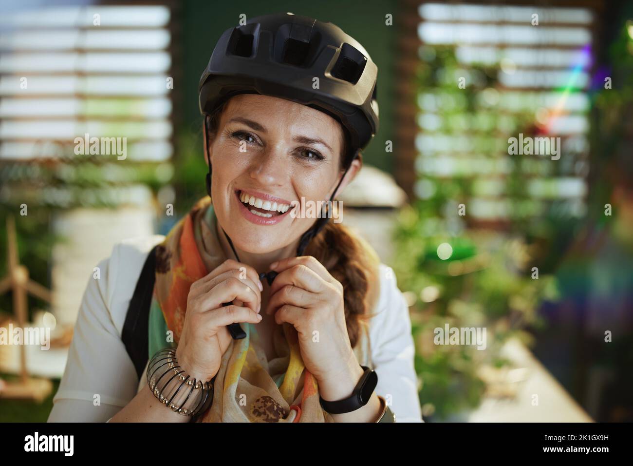 Portrait of smiling elegant business woman in bike helmet in modern eco ...