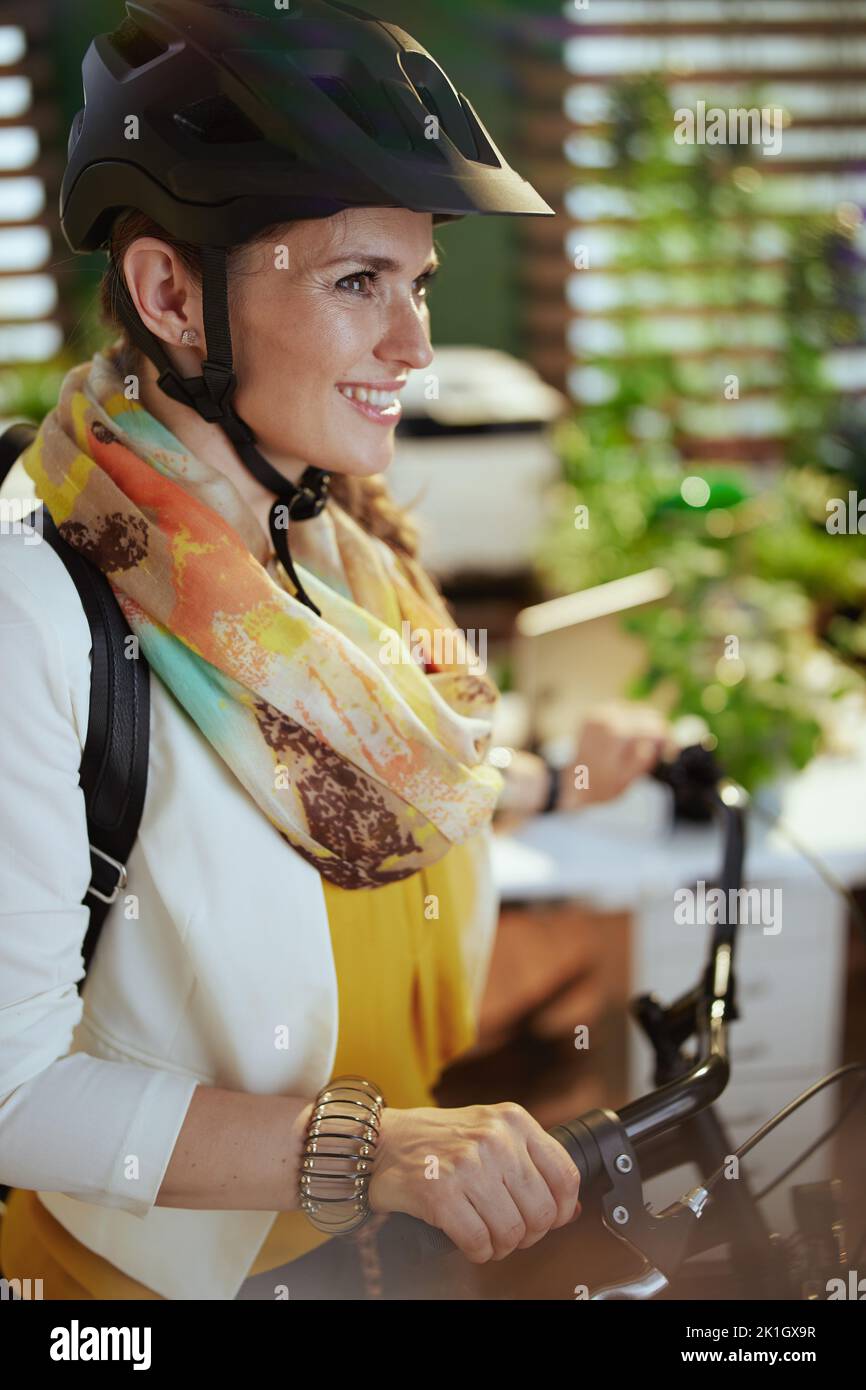 happy stylish middle aged business woman in bike helmet with bicycle in ...