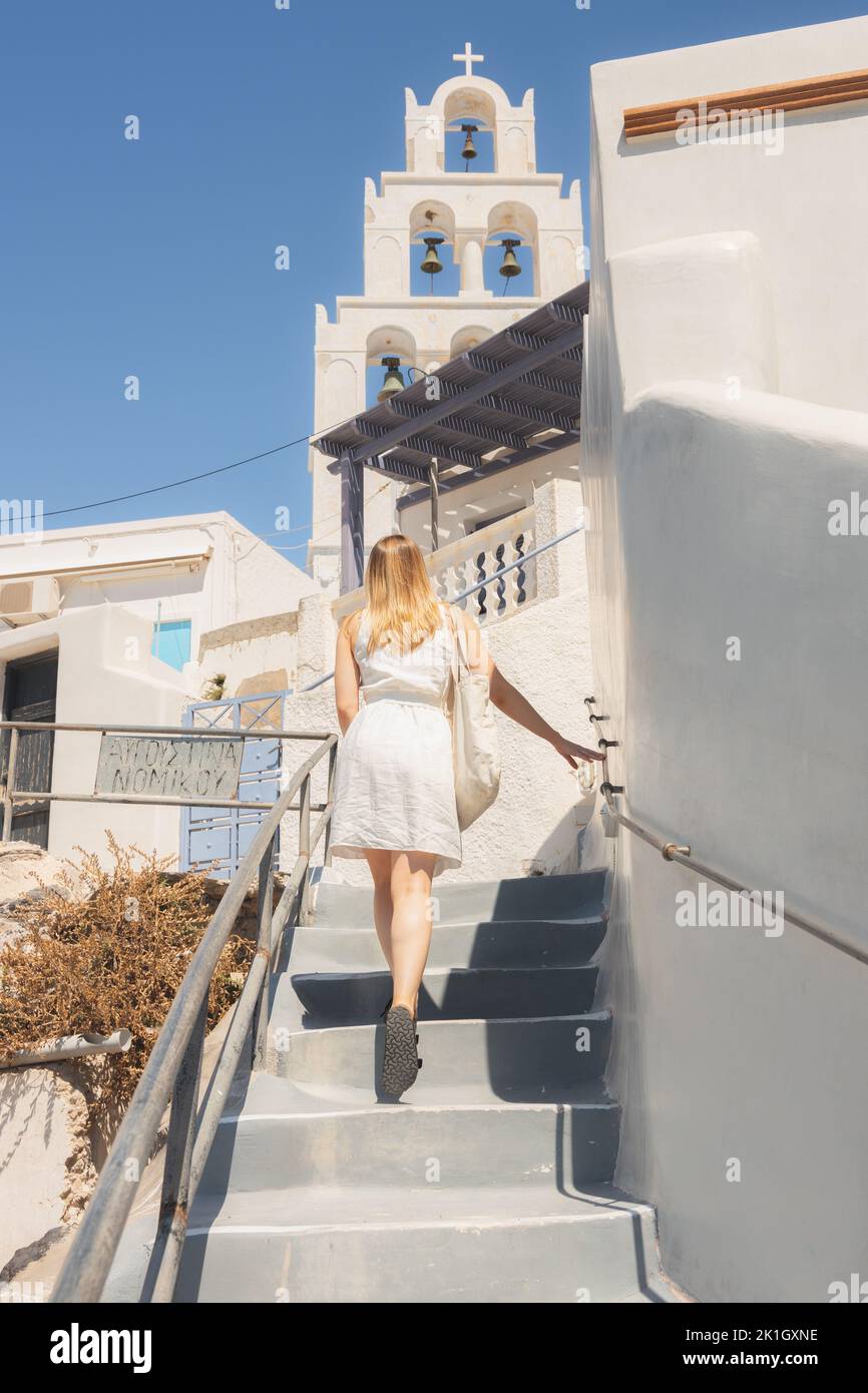 A young blonde female tourist explores the traditional old town streets ...