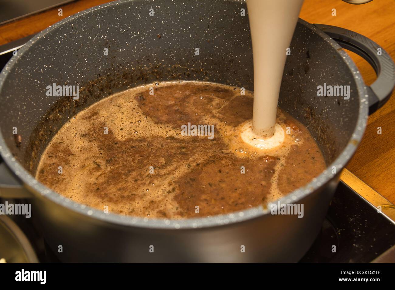 Puree the sauce for a pot roast with a blender Stock Photo - Alamy