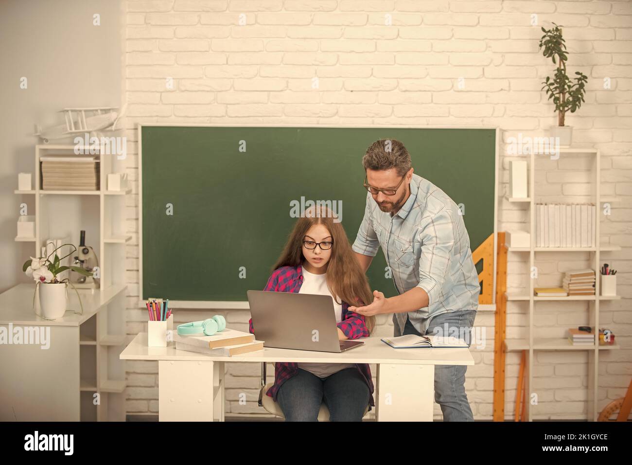 back to school. childhood education. busy pupil and tutor with laptop ...