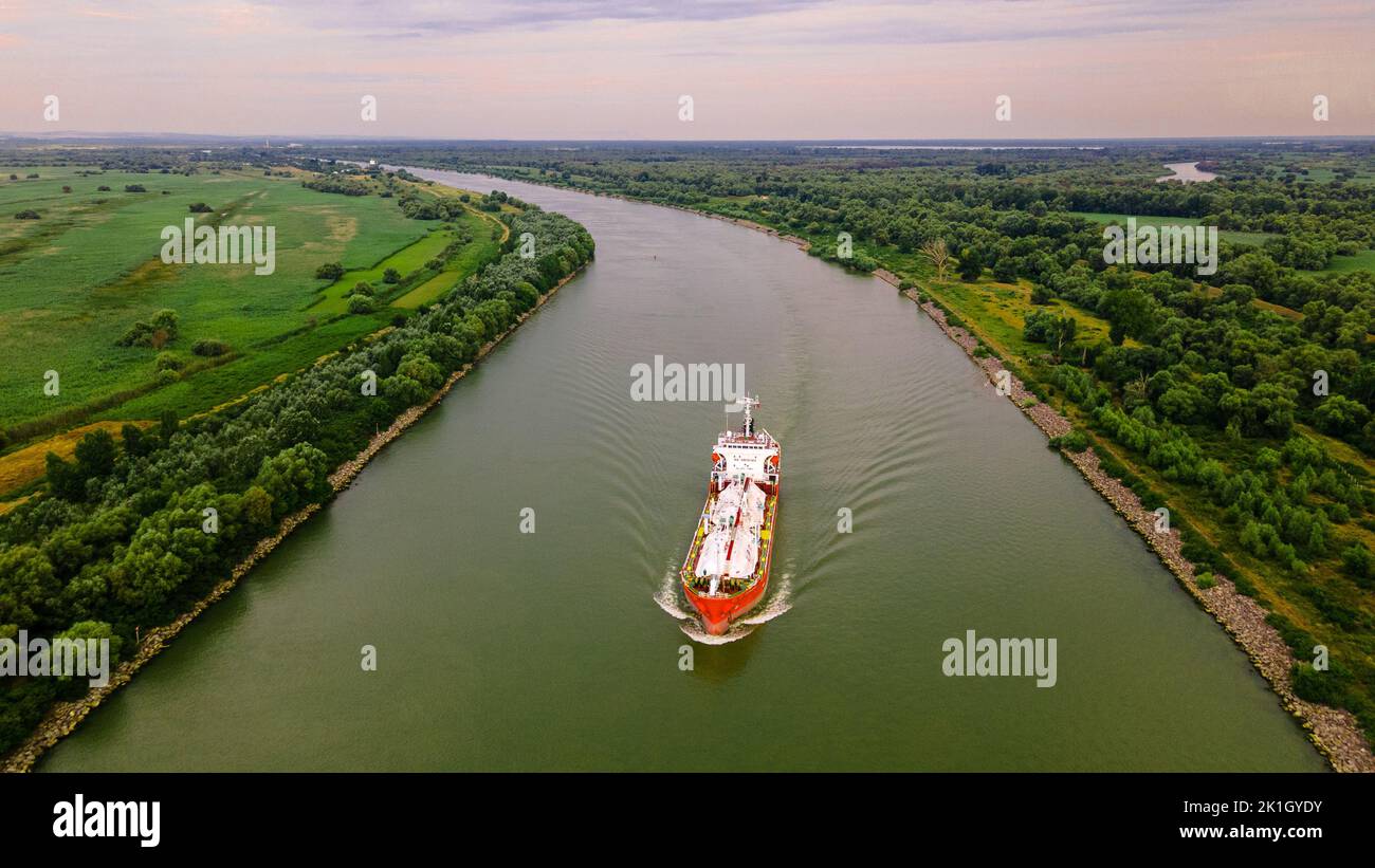 Aerial photography of a cargo transport ship seen on Danube at sunrise ...
