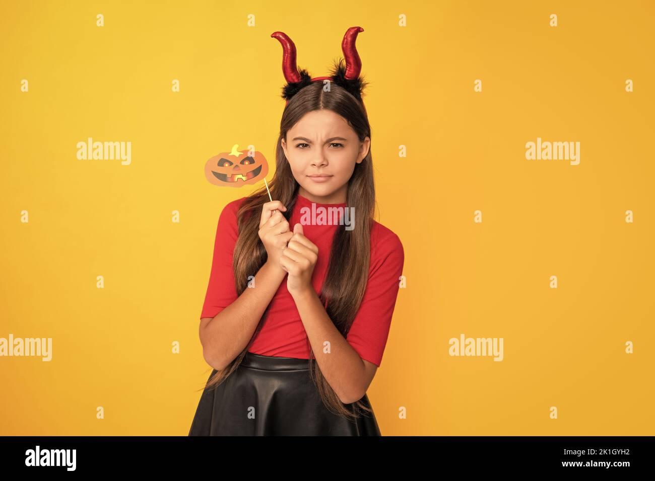 devil kid with pumpkin party accessory. trick or treat. teen girl on ...