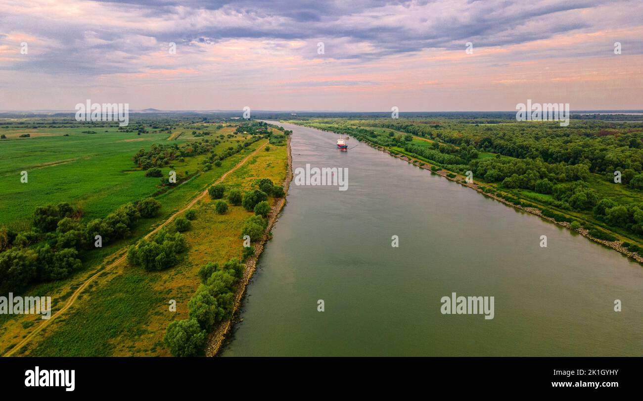 Aerial photography of a cargo transport ship seen on Danube at sunrise ...