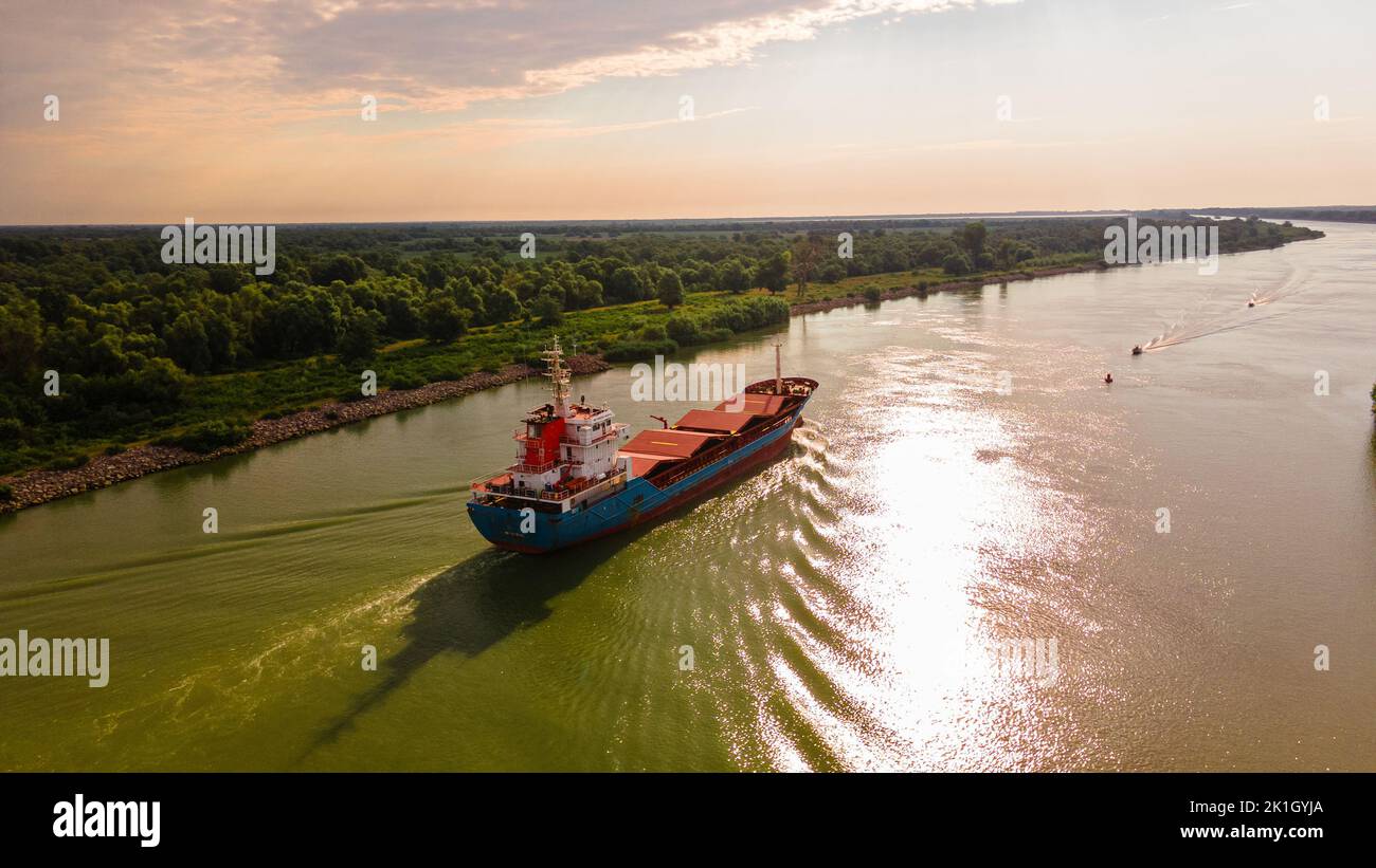 Aerial photography of a cargo transport ship seen on Danube at sunrise ...