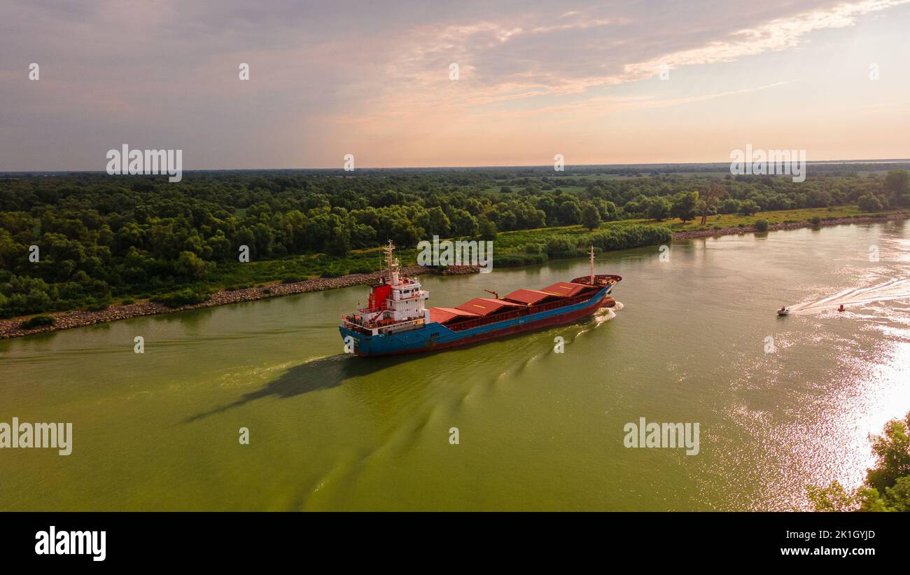 Aerial photography of a cargo transport ship seen on Danube at sunrise ...