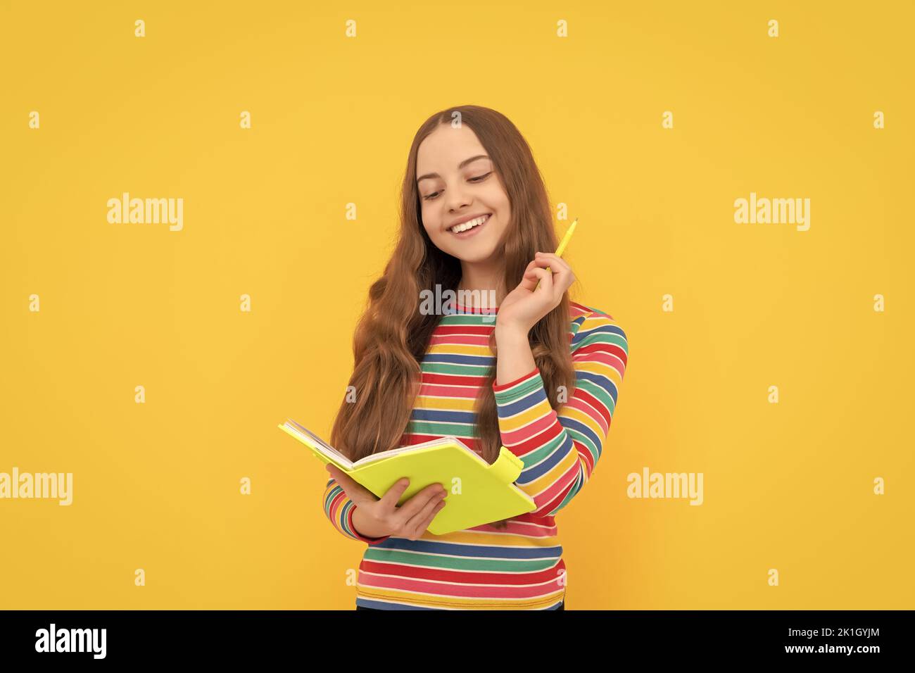 Reading her school essay. Happy girl hold pen and copybook. Essay task ...