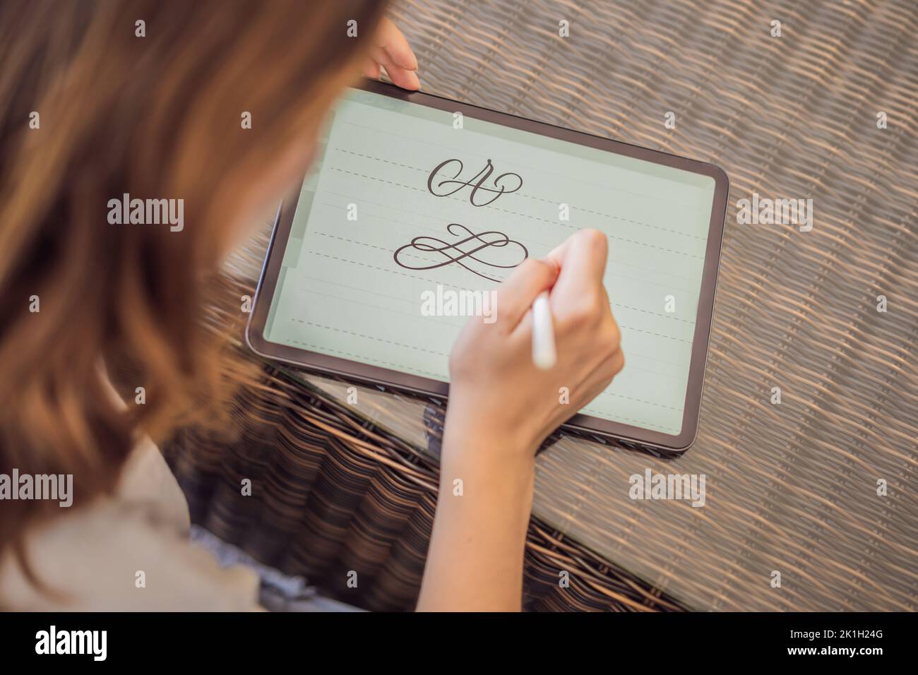 Calligrapher Young Woman writes phrase on digital tablet. Inscribing ...