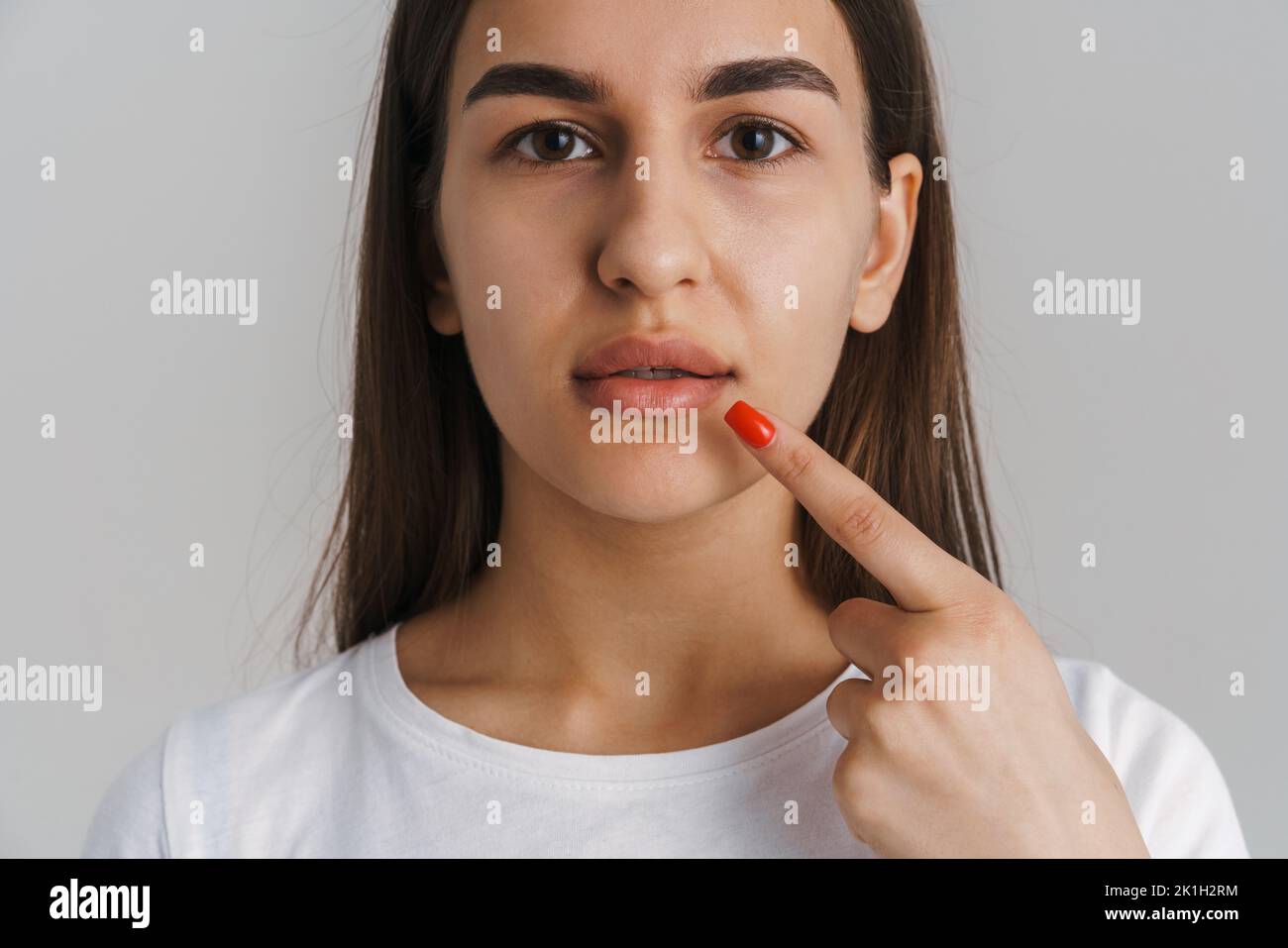 Portrait of a confused young casual white woman in t-shirt with long ...