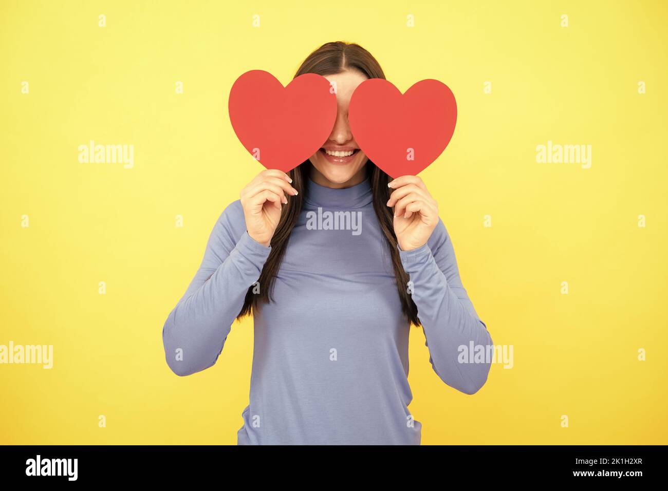 Happy woman hold red heart. Beautiful female model posing on isolated ...