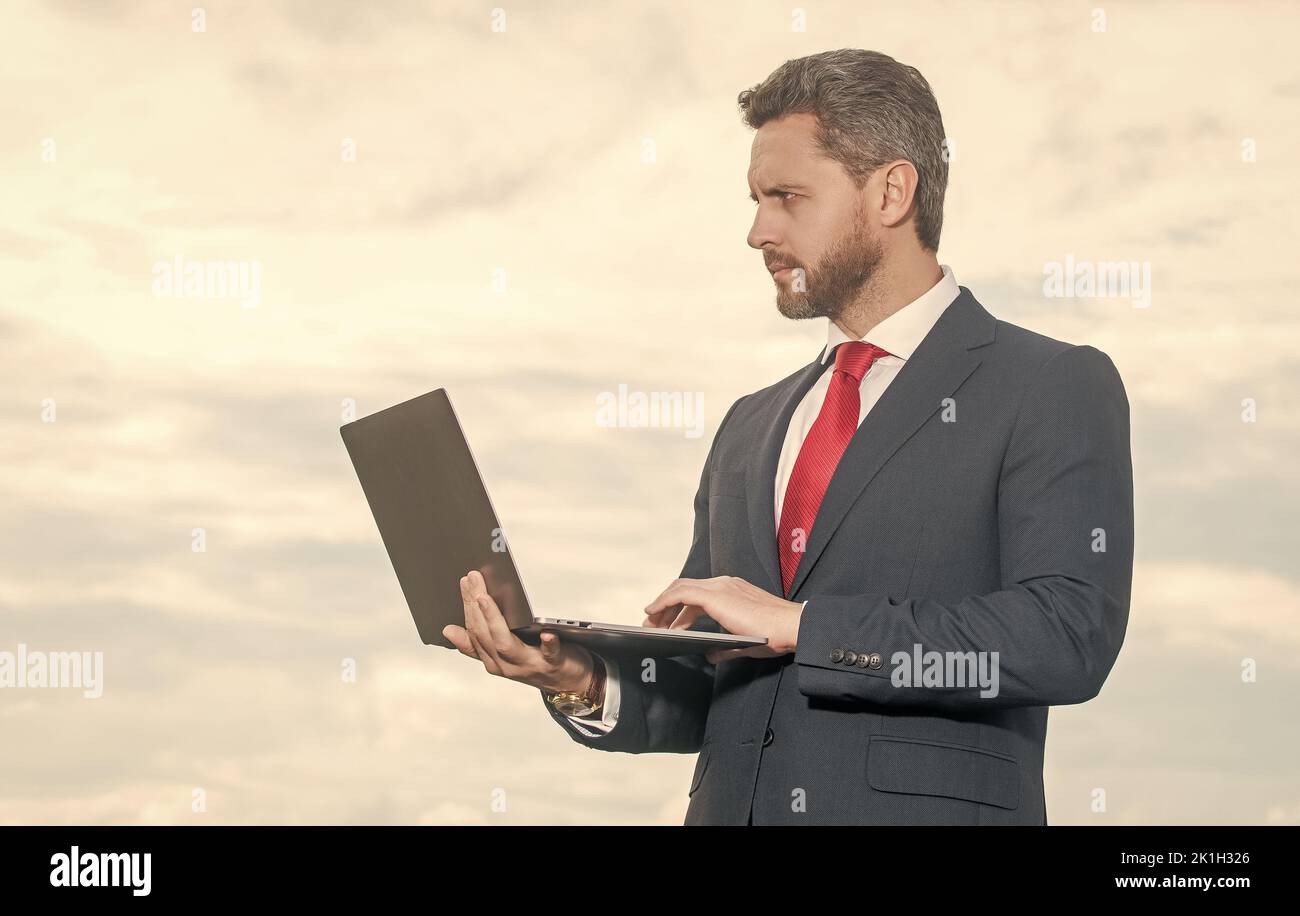 entrepreneur in suit using laptop on sky background Stock Photo - Alamy