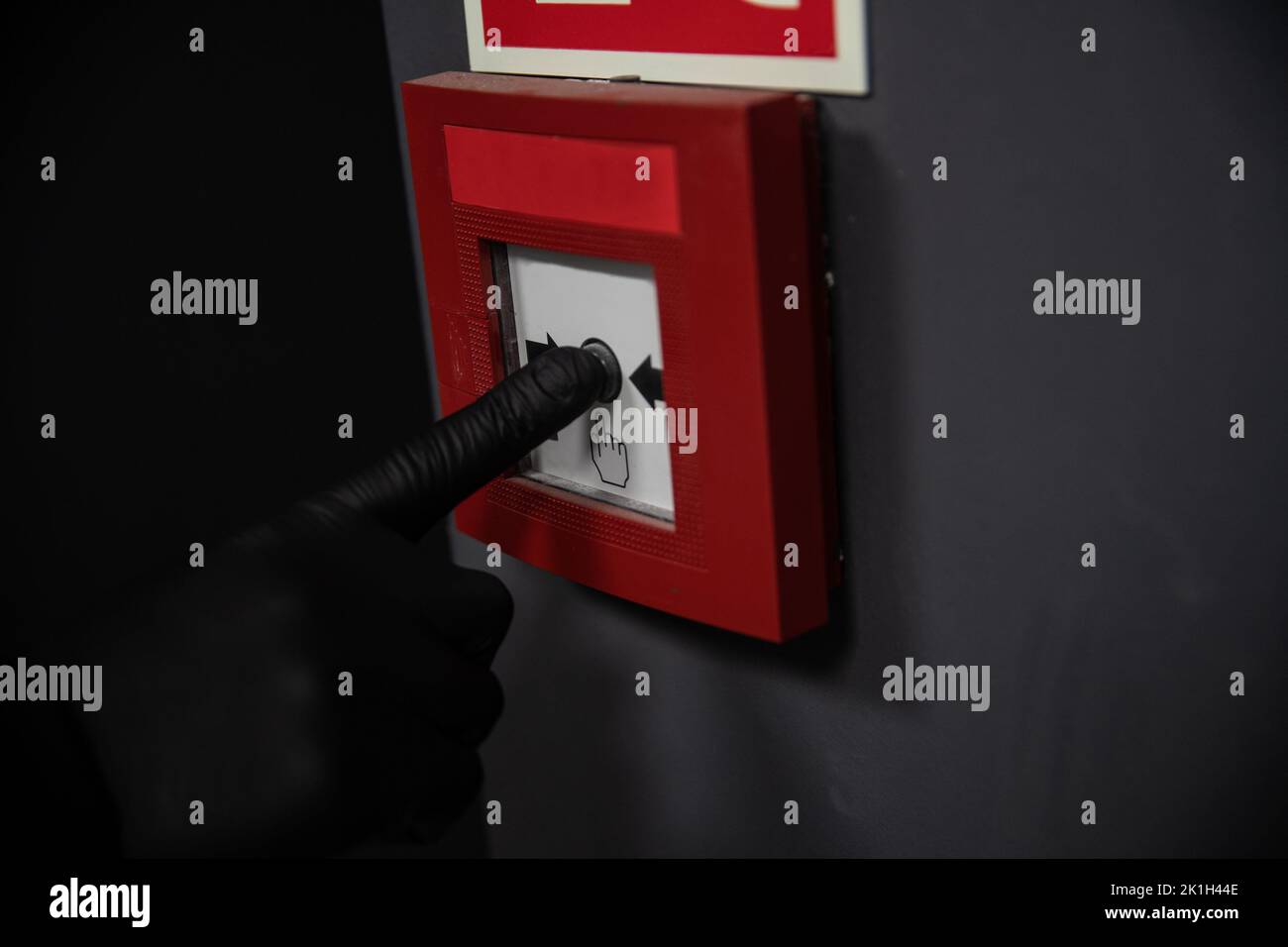 Man in black gloves turning on the fire alarm Stock Photo - Alamy
