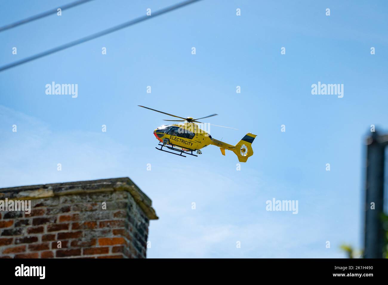 An electricity helicopter over rooftops checking power lines Stock ...