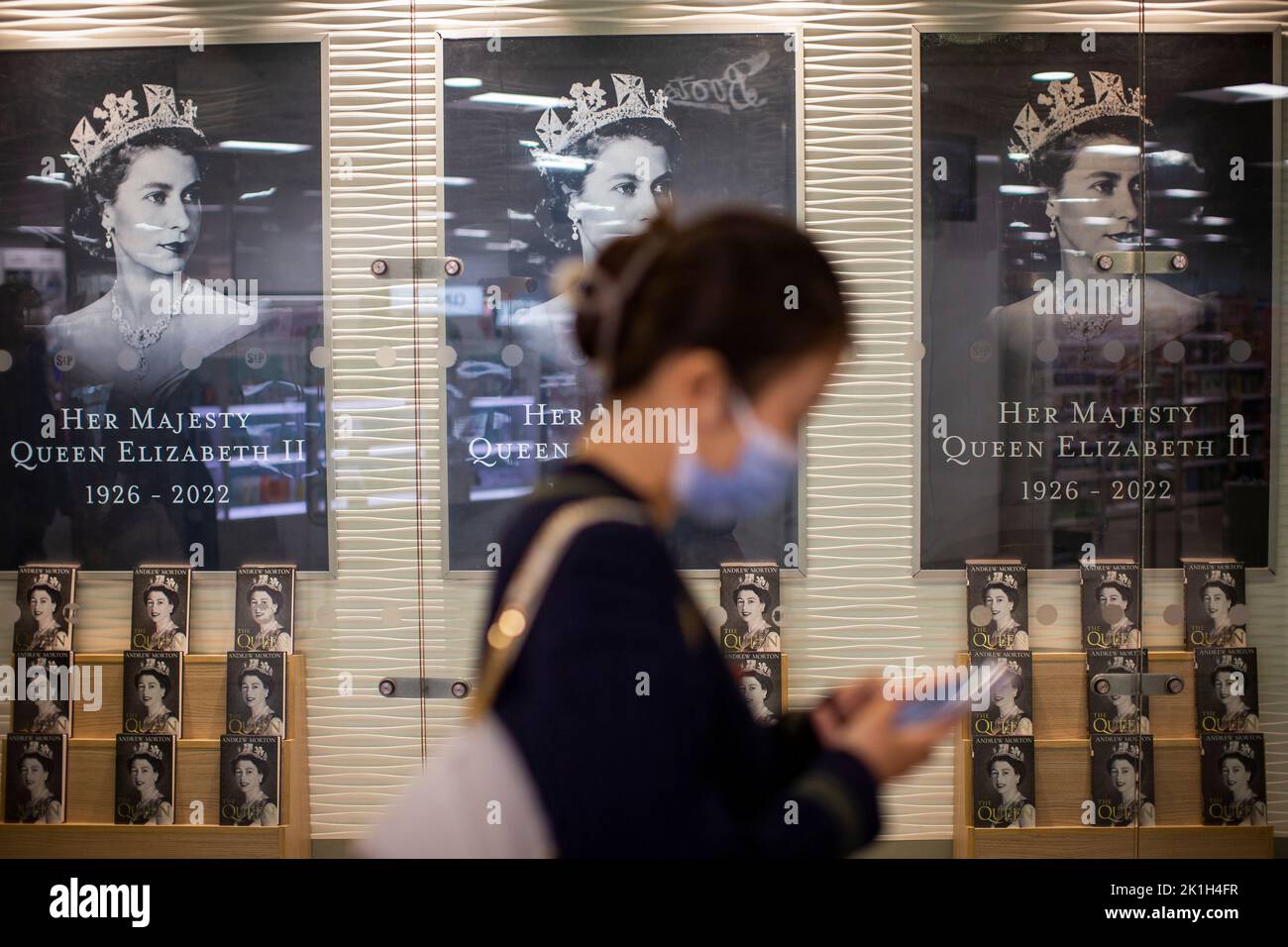 London, UK. 18th Sep, 2022. A young lady walks past the display of ...